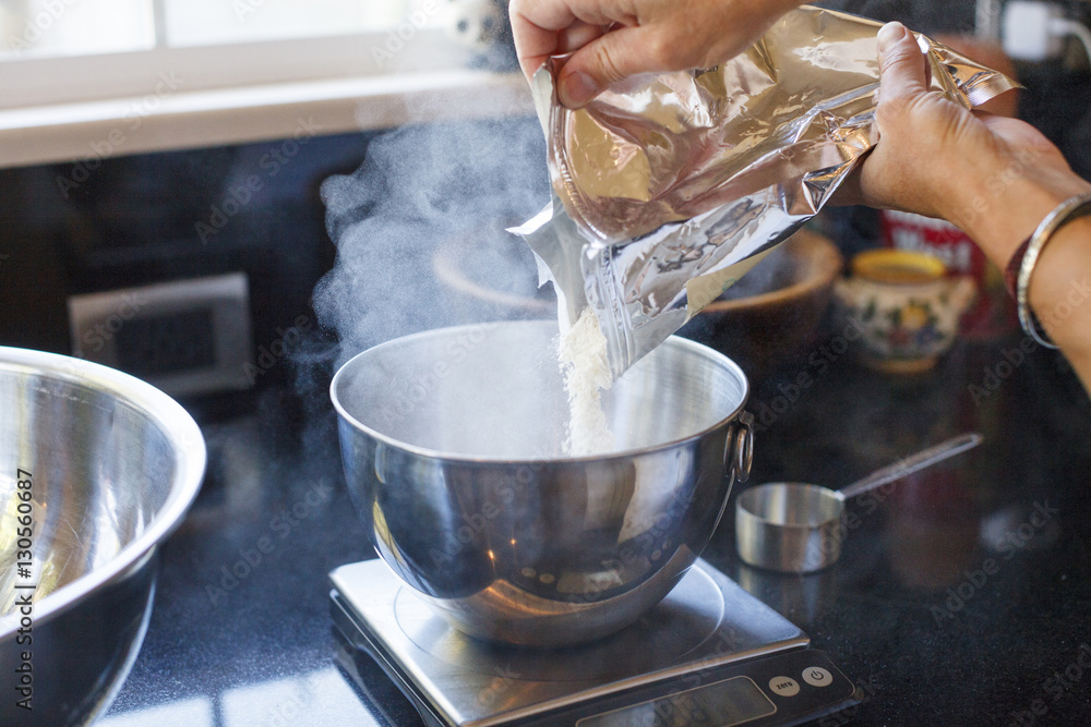 Cropped image of woman pouring powder from packet in container on ...