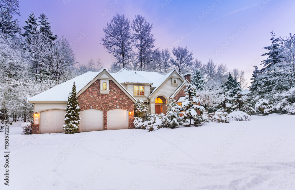 Driveway view of snowy home - daylight fades over a snow-covered ...