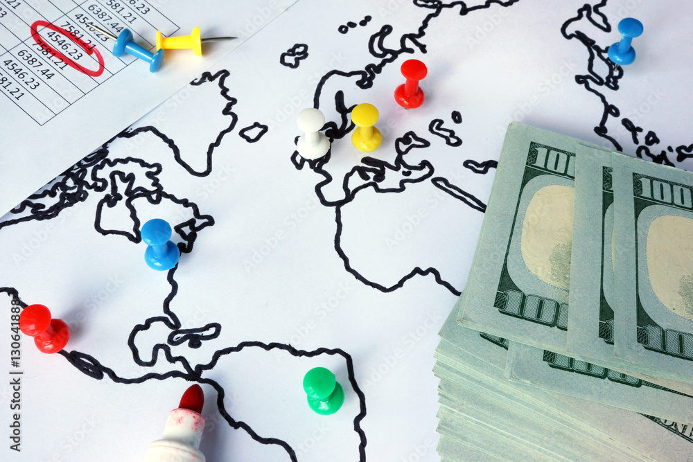 Thumb tacks in a world map and cash. Anti-money laundering (AML ...