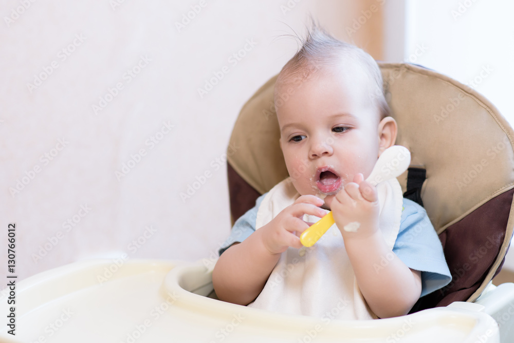 baby holding a spoon in his mouth Stock Photo | Adobe Stock