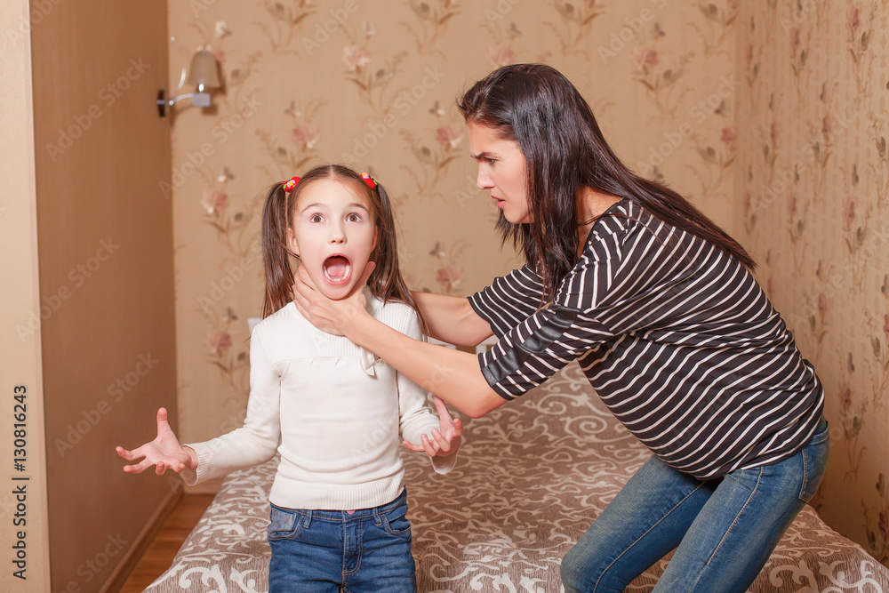 Mother trying to strangle her little daughter. Stock Photo | Adobe Stock
