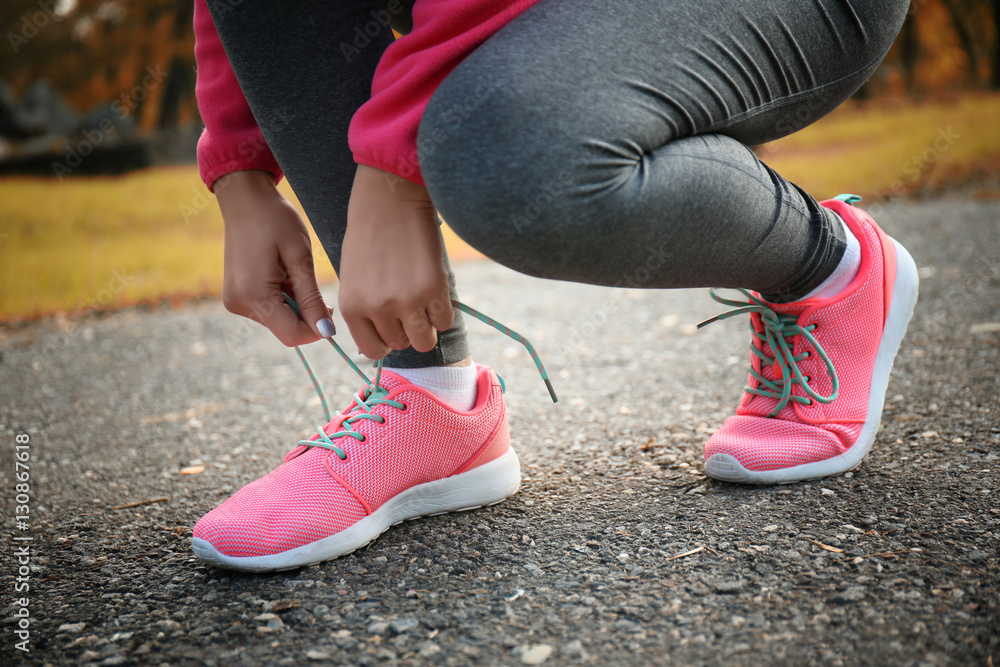 Woman tying up jogging shoes on ground wall mural wallpaper ...