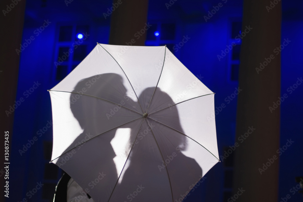 Young couple hugging and kissing, hide behind umbrella at night Stock ...