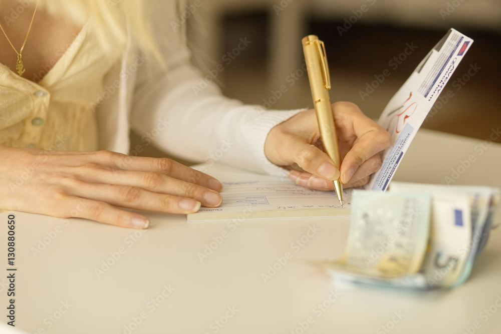 Signing a cheque Stock Photo | Adobe Stock