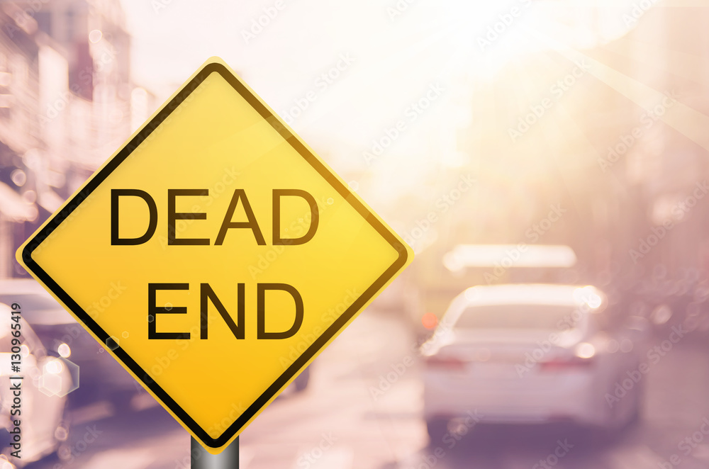 Dead end warning sign on blur traffic road with colorful bokeh light ...