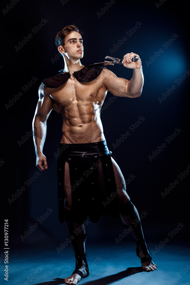 Portrait of handsome muscular gladiator with sword. Isolated. Studio ...