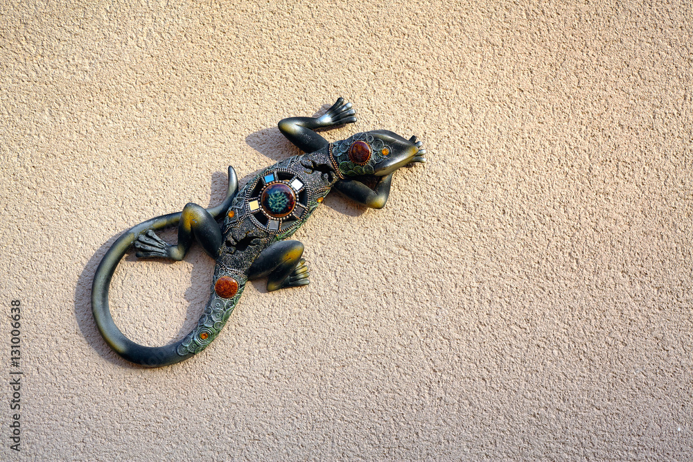 Bright decorative model lizard crawling up the wall. Stock Photo ...