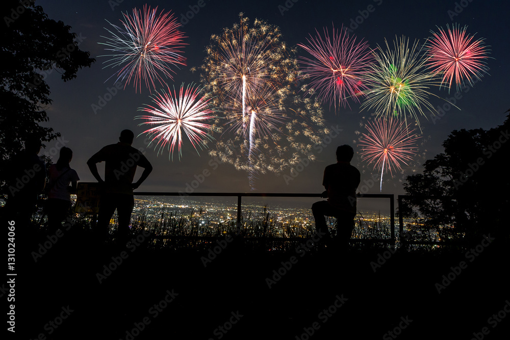 People looking at fireworks in the sky over the city Stock Photo ...