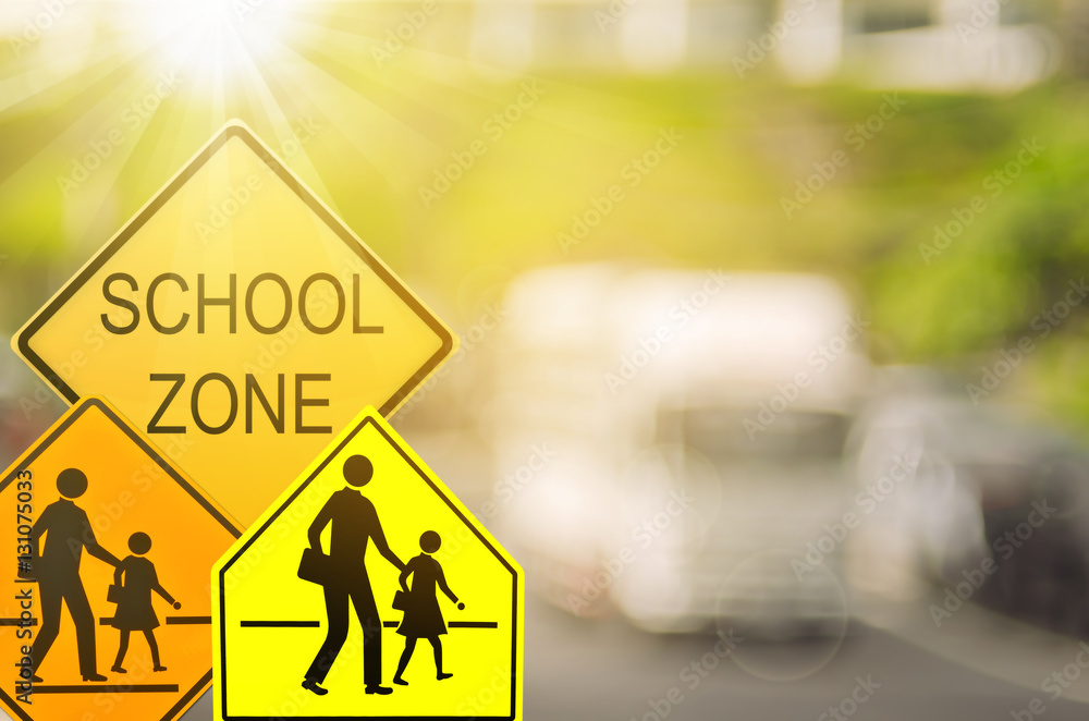School zone warning sign on blur traffic road with colorful bokeh light ...