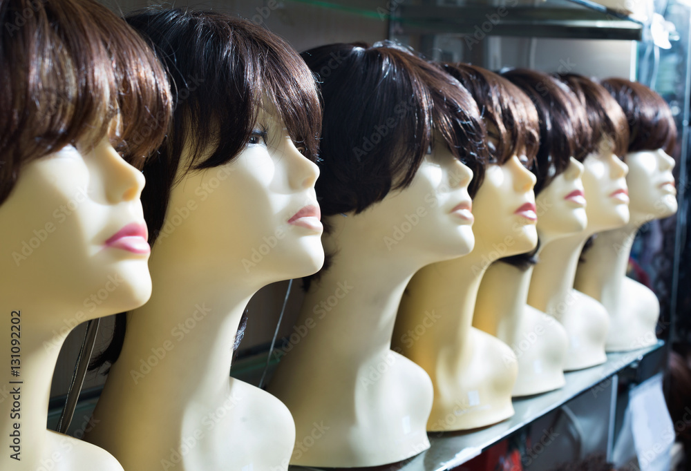 Mannequins with brown-haired and brunet style wigs on shelves Stock ...
