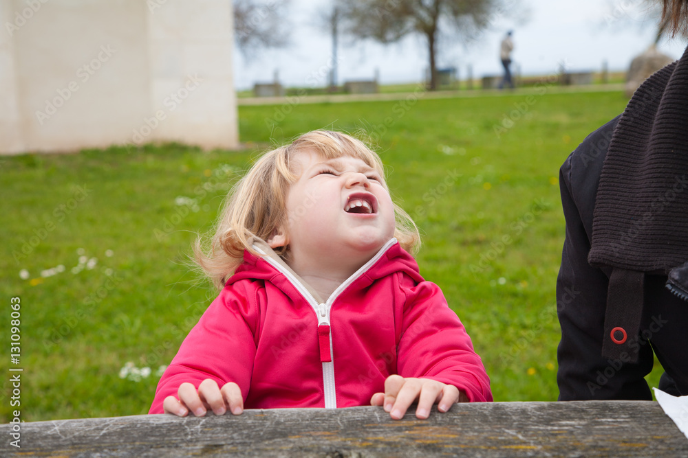 little blonde cute child sitting open mouth screaming and shouting ...