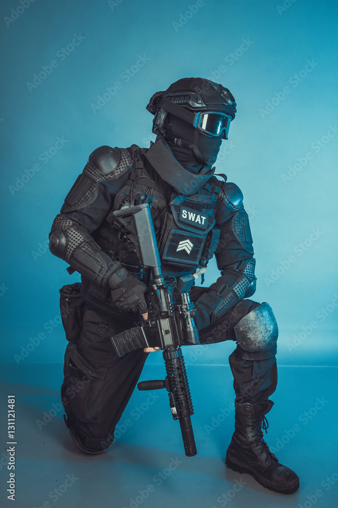 Member of the SWAT squad with an assault rifle in a black uniform on ...