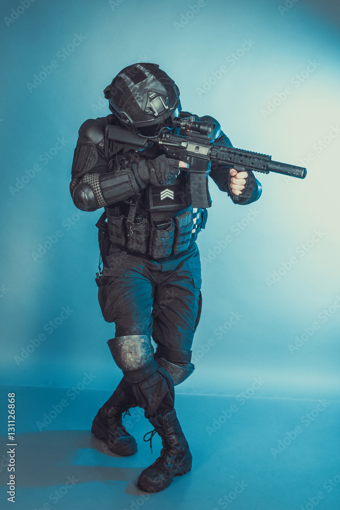 Member of the SWAT squad with an assault rifle in a black uniform on ...