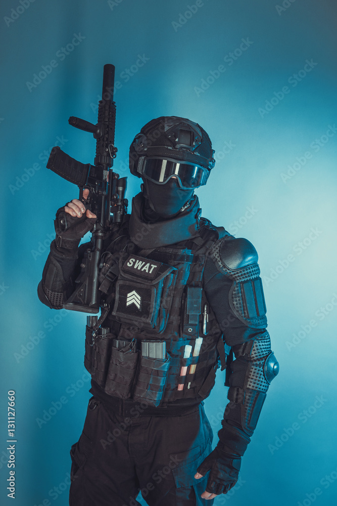 Member of the SWAT squad with an assault rifle in a black uniform on ...