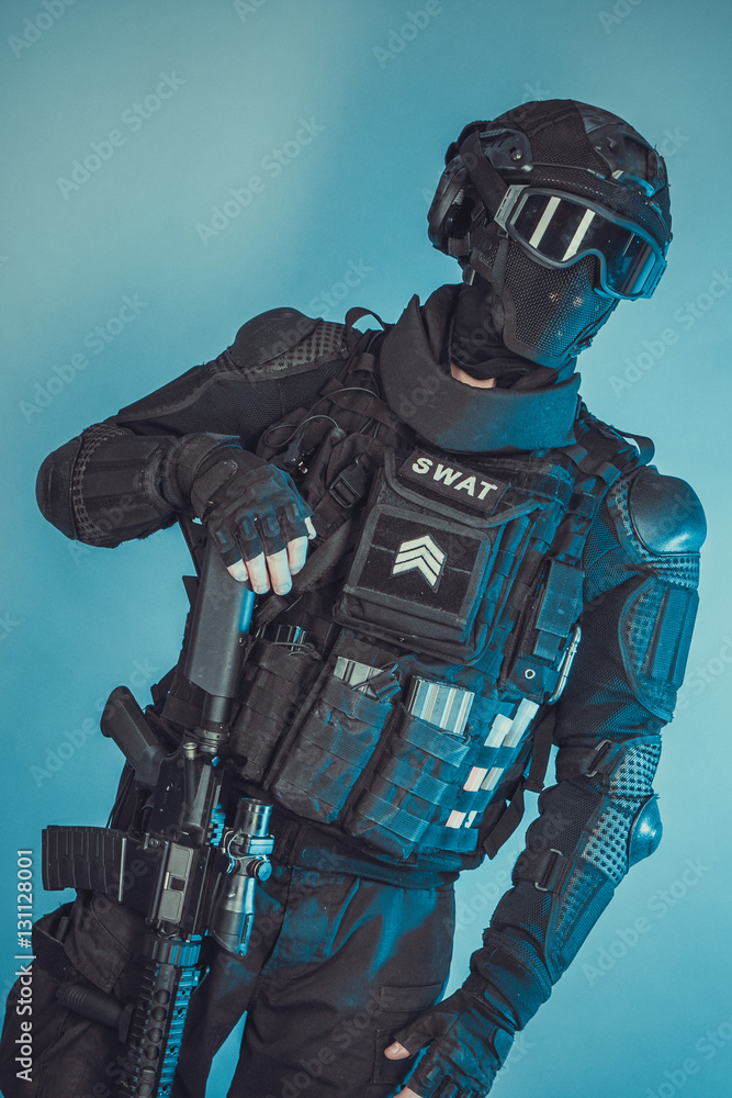 Member of the SWAT squad with an assault rifle in a black uniform on ...