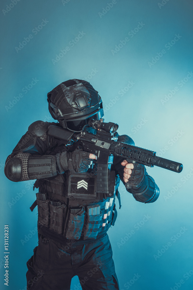 Member of the SWAT squad with an assault rifle in a black uniform on ...