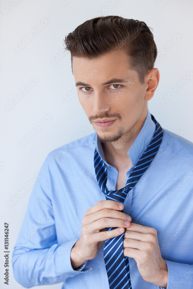 Closeup of Serious Young Business Man Binding Tie Stock Photo | Adobe Stock