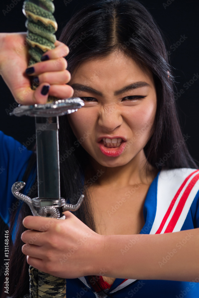 Serious looking Asian lady taking sword for battle or fight while ...