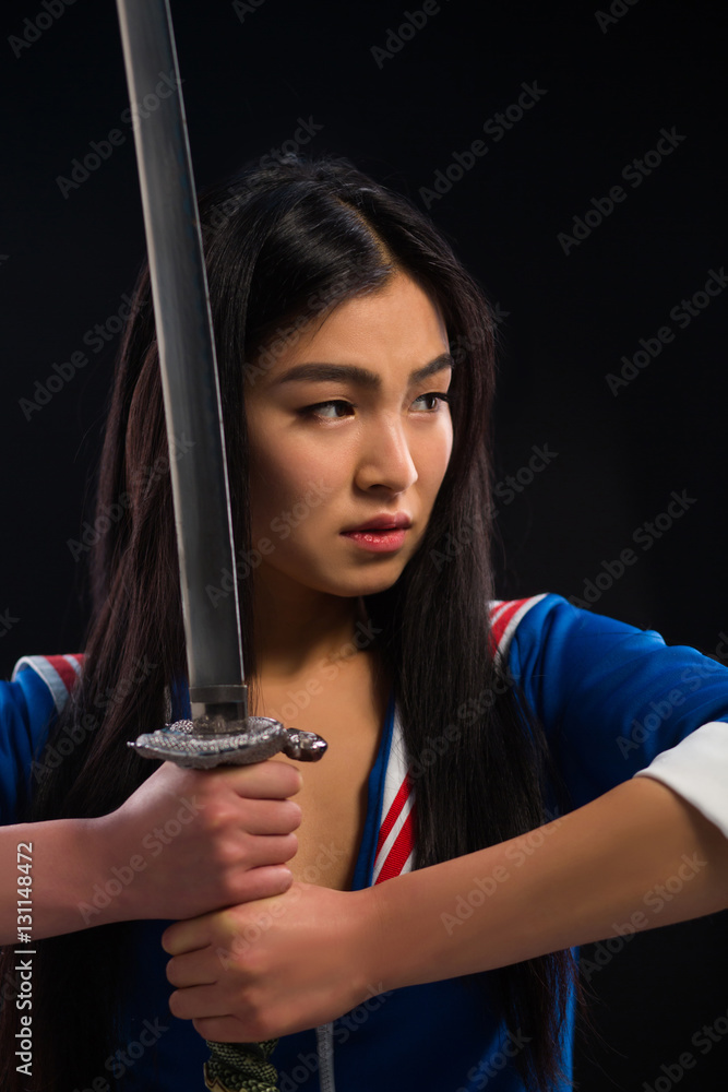 Closeup portrait of Asian lady with sword in studio. Beautiful woman ...