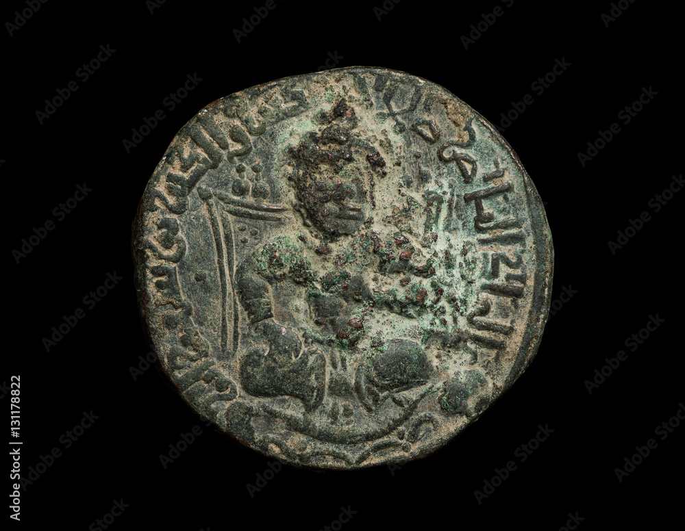 Ancient bronze islamic coin with seated figure isolated on black Stock ...