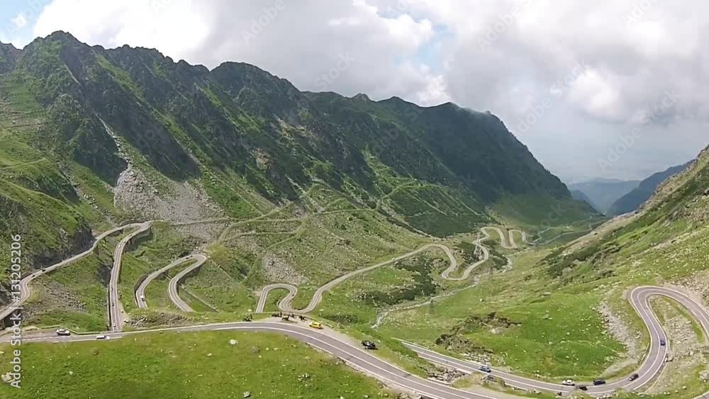 Scenic paved road crossing mountain ridge at high altitude with cars ...