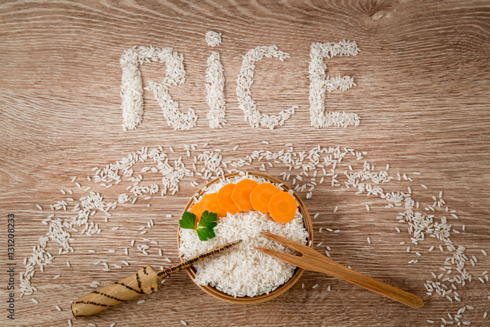 Word rice created from rice. Rice and carrots with wooden fork and ...