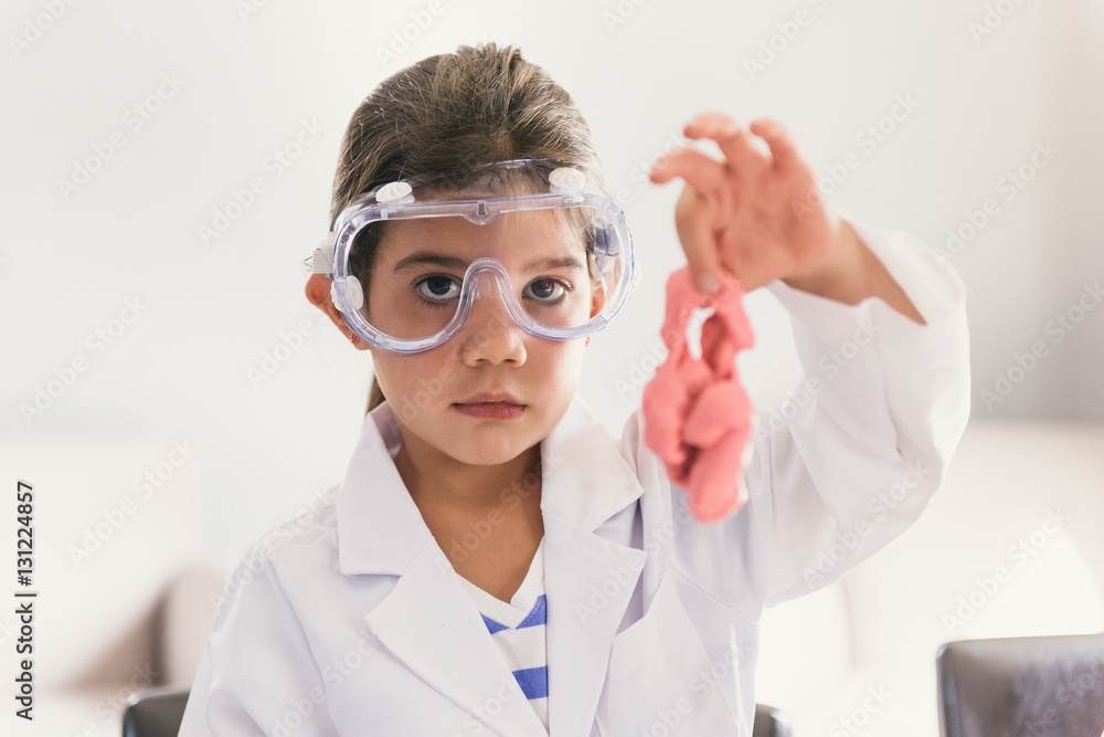 Girl wearing safety goggles holding up slime from history set Stock ...