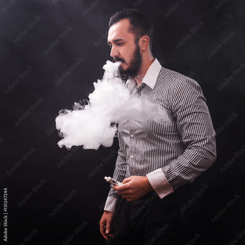 Young man vaping with RDA. Black Background Stock Photo | Adobe Stock