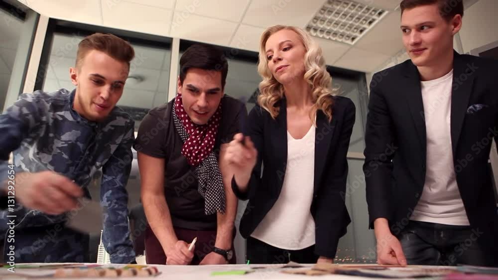 Designers at Work/A group of young designers led by the head are ...