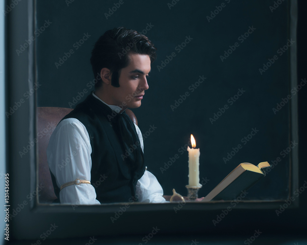 Retro victorian man reading book by candlelight sitting by windo Stock ...