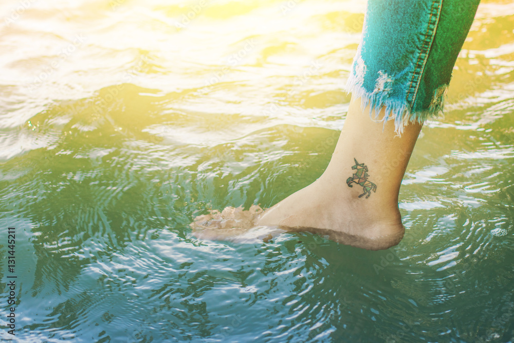 Woman relaxing and dipping feet in water Stock Photo | Adobe Stock