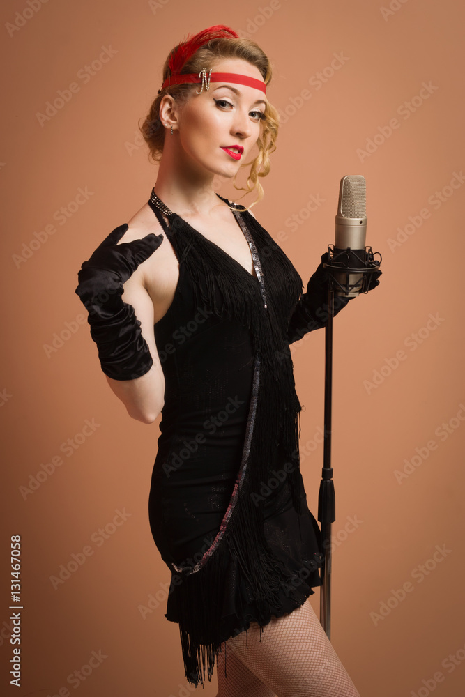 Pretty actress in black retro dress singing with microphone Stock-Foto ...