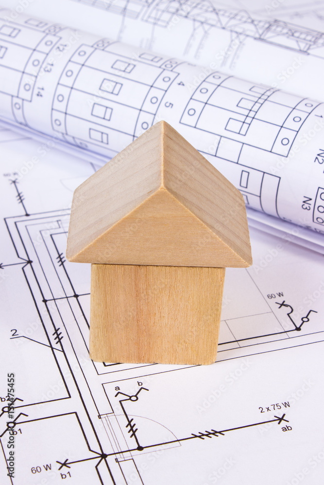 House of wooden blocks and rolls of diagrams on construction drawing of ...