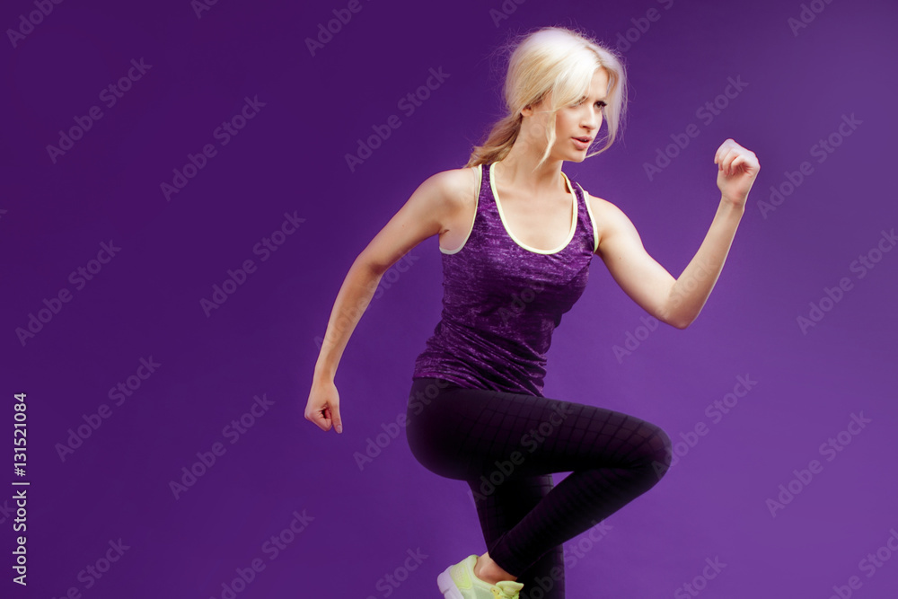 Beautiful young girl in a pose runner. Studio background, purple Stock ...