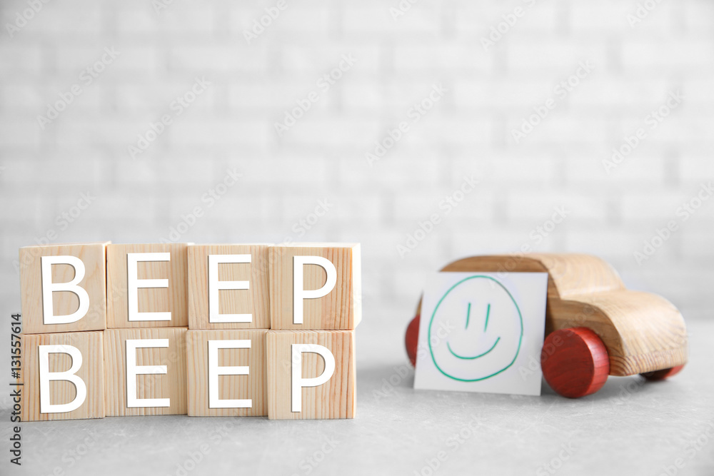 Cubes with words BEEP BEEP and toy car on brick wall background Stock ...