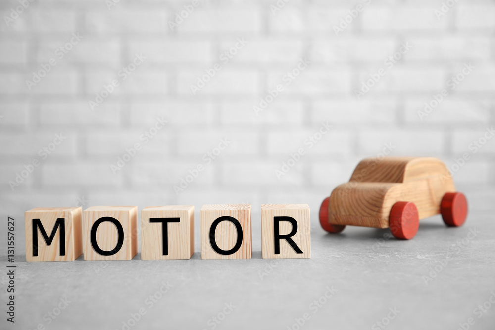Cubes with word MOTOR and toy car on brick wall background Stock Photo ...