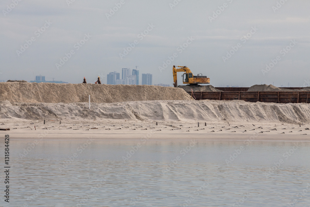 Sand replenishment ship on shore for land reclamation Photos | Adobe Stock