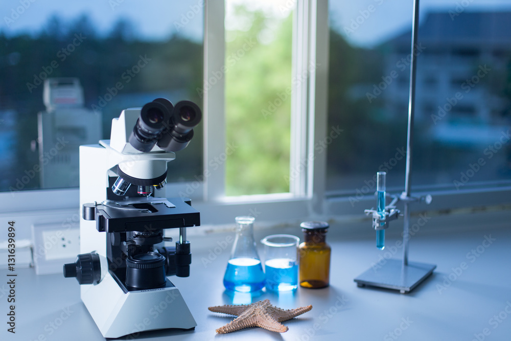 Microscope with examples of animals, lab glassware, science laboratory ...