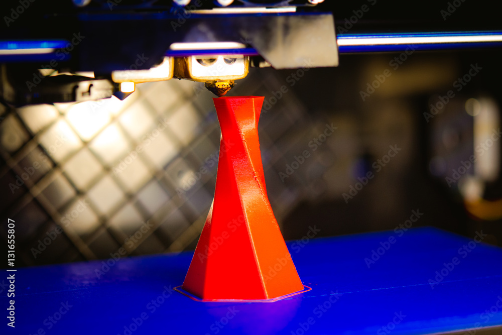 3D printer printing isolated volume triangular object red color on the ...