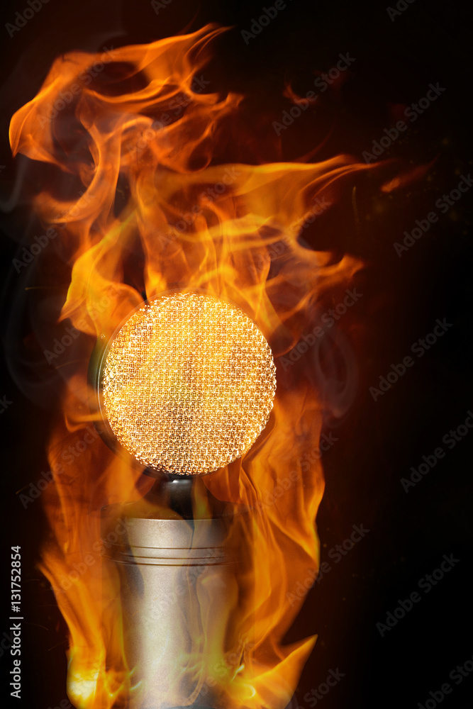 Golden studio microphone stands on the rack and burn a bright flame on ...