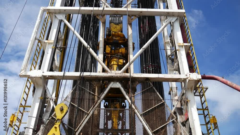 Top Drive System (TDS) moving along the dolly track of derrick while ...