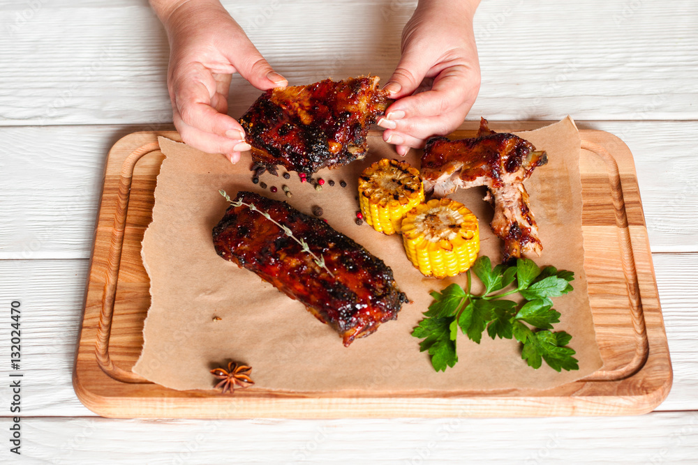 Eating grilled tasty ribs top view. Female hands holding barbecue meat ...