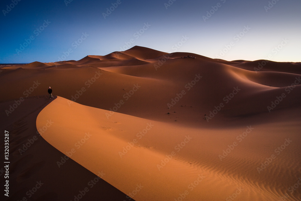 woman at Sunrise at the Dunes of Hassi Labiad, Morocco Photos | Adobe Stock
