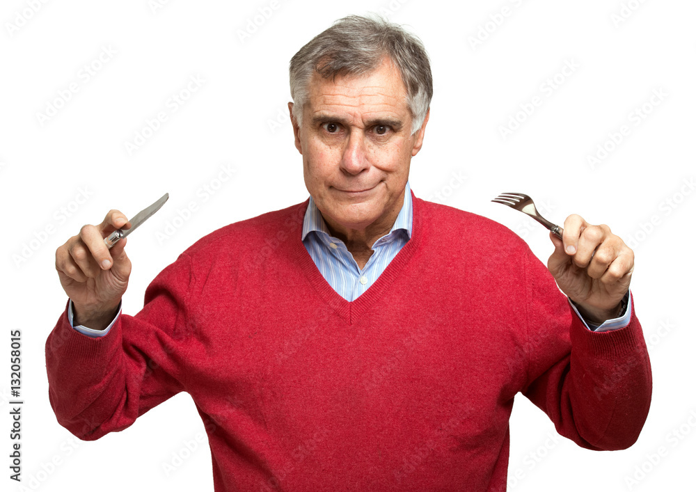 Senior man holding a fork and a knife isolated on a white background ...