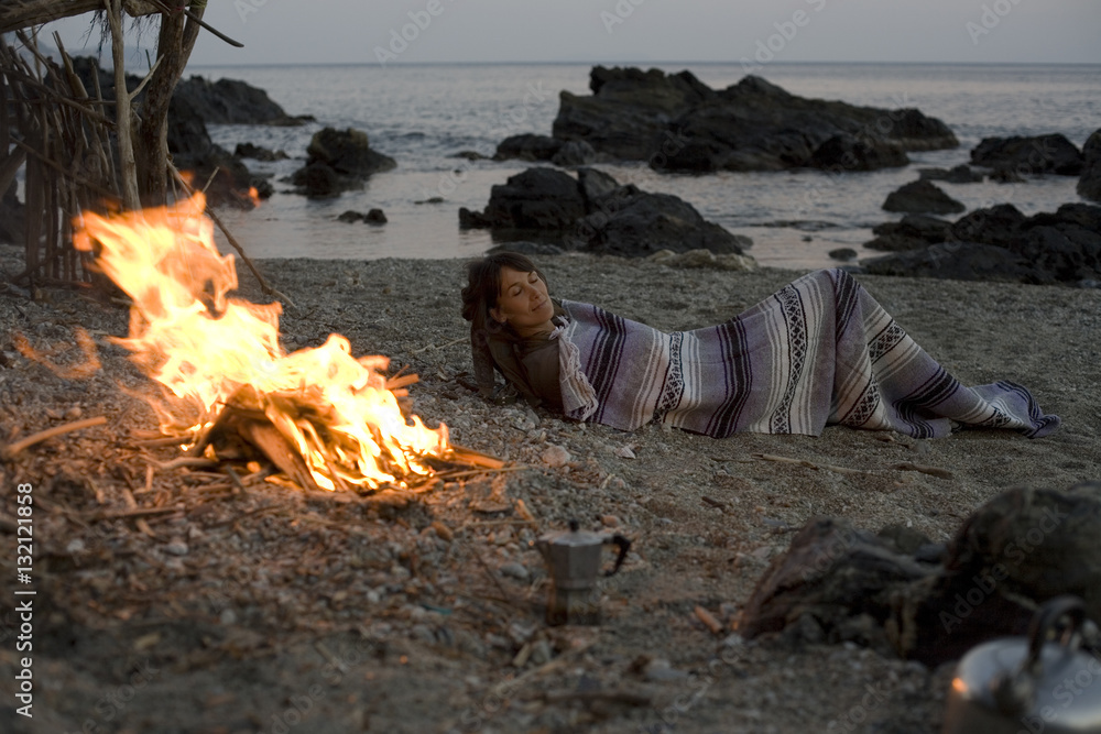 femme qui campe en dormant sur la plage au coin du feu à la belle ...