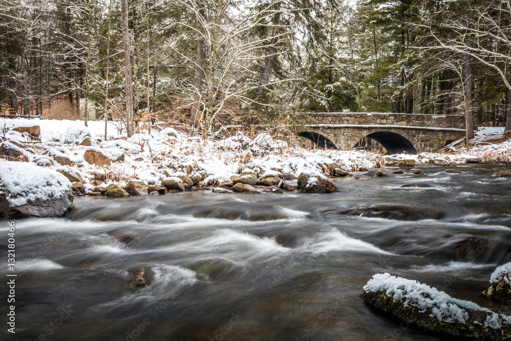 Winter river scene in the snowy forest and double arch stone bridge in ...