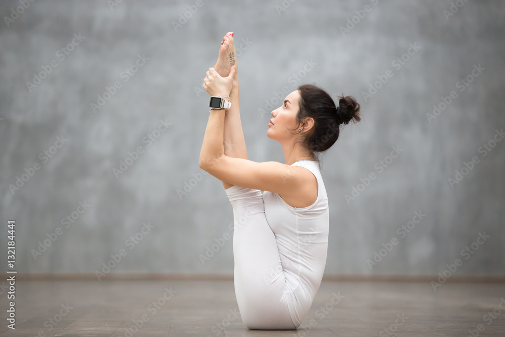 Side view portrait of beautiful young woman working out against grey ...