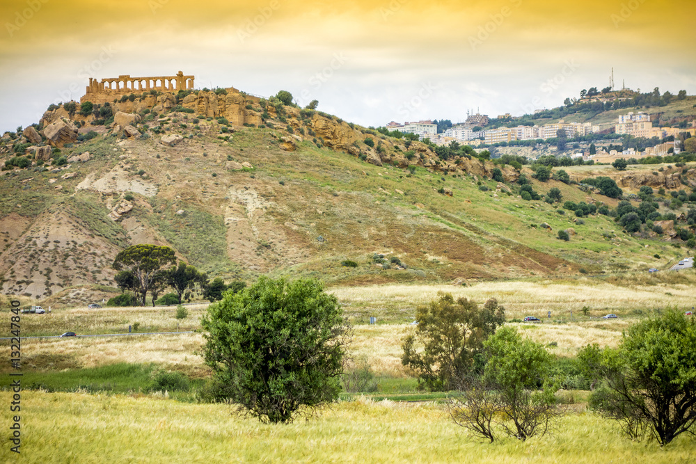 Ancient Greek temple ruins and the city of Agrigento in the background ...