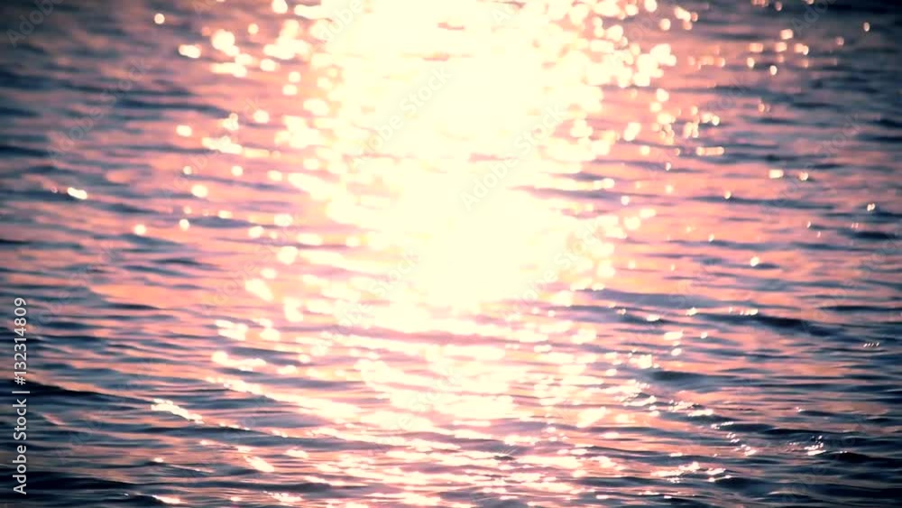 Water glittering in sunlight with sun path on purple and blue water ...