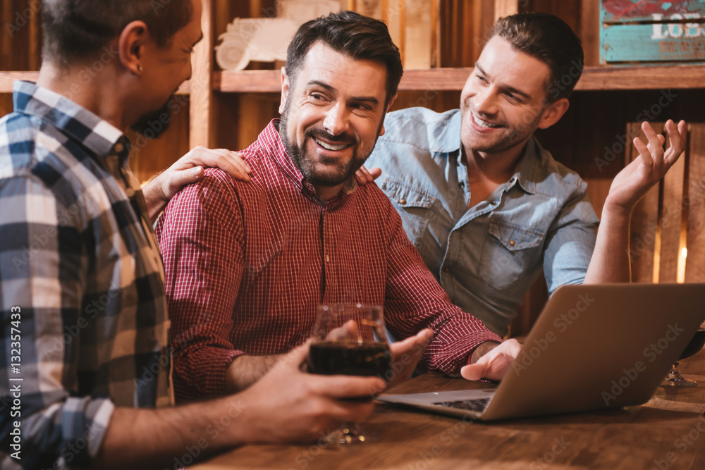 Delighted nice men looking at their friend Stock-Foto | Adobe Stock